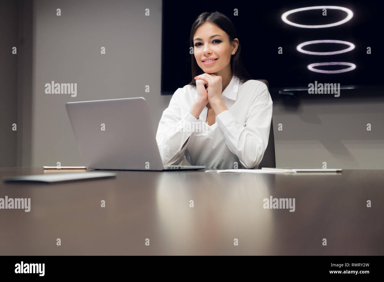 Young female executive smiling during meeting in office conference room ...