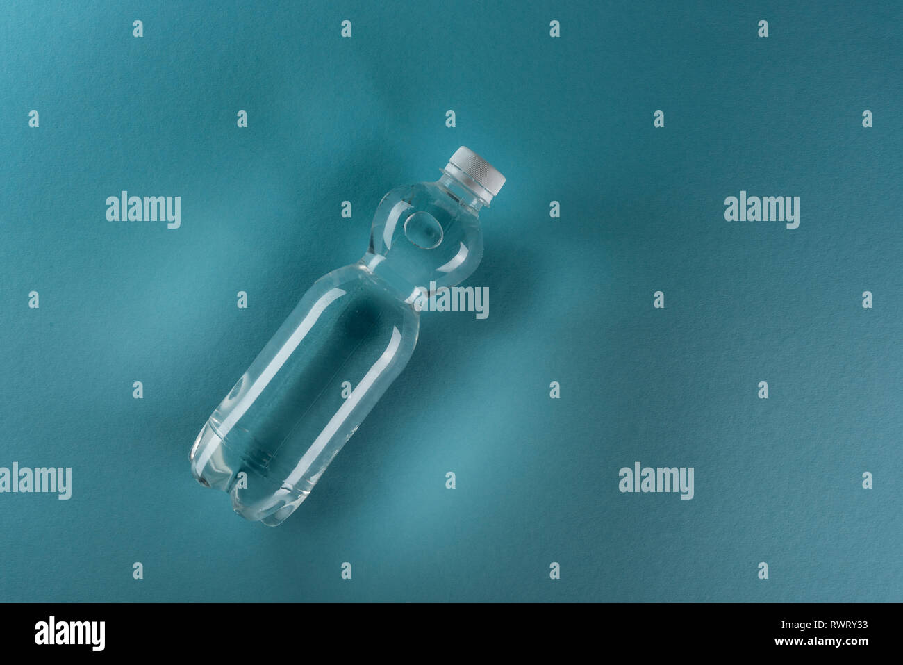 top view of plastic water bottle on turquoise background with copy ...