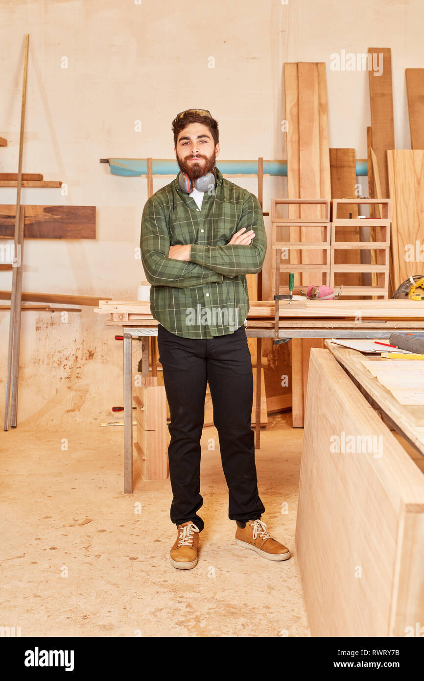 Young man as a self-confident joiner or carpenter as a boss in his ...