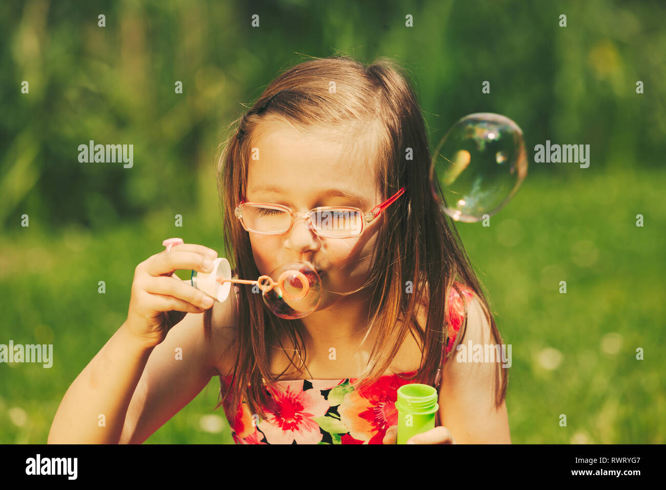 Little girl child blowing bubbles outdoor. Kid having fun in park ...