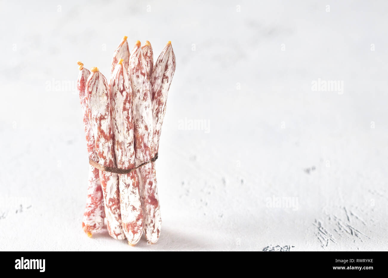 Snack fuet sausages on the wooden background Stock Photo - Alamy