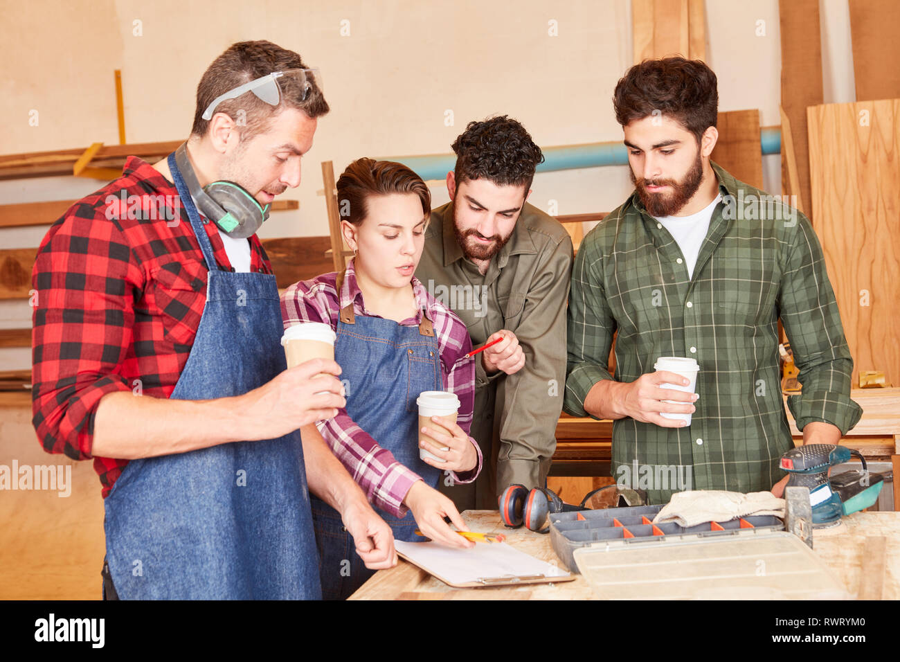 Young craftsman team with apprentices in a meeting in the carpenter ...