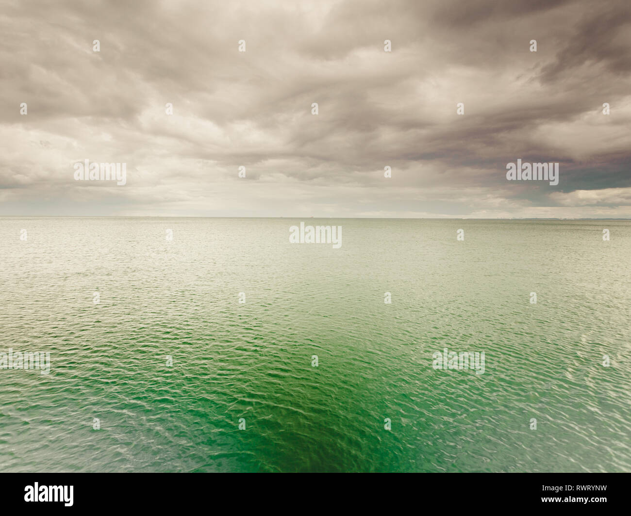 Minimalist idyllic shot of horizontal sea water and sky during cloudy ...
