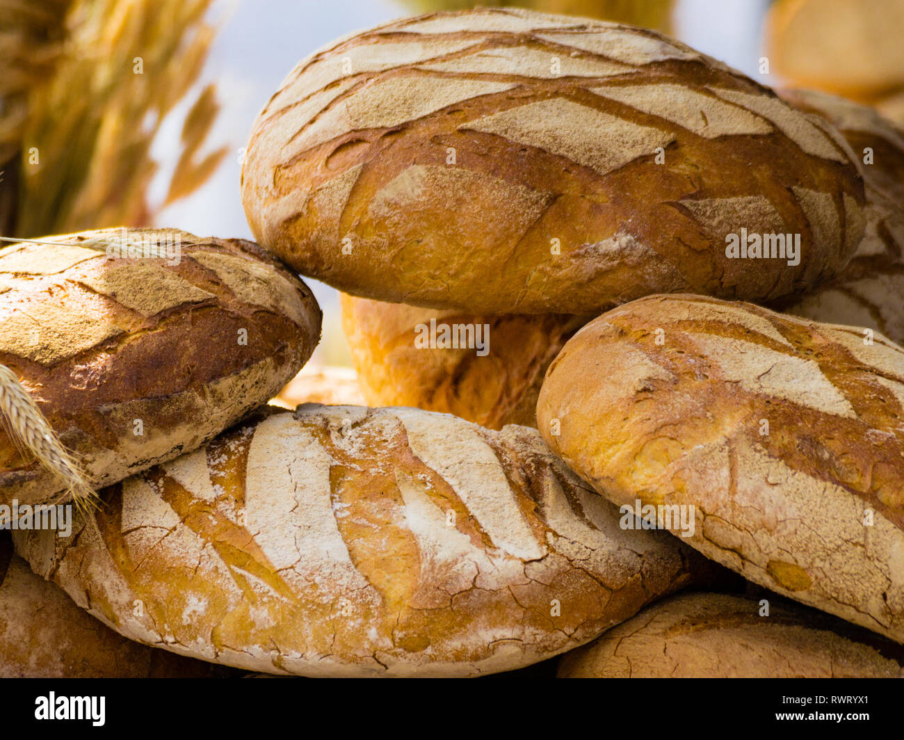 many rustic baked traditional rye bread loaves on a market stall ...