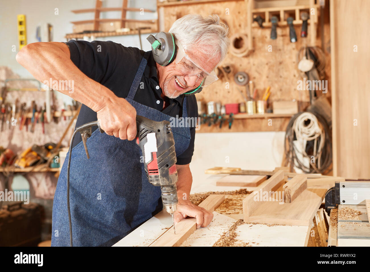 Senior as a carpenter Master works with the hand drill in the joinery ...