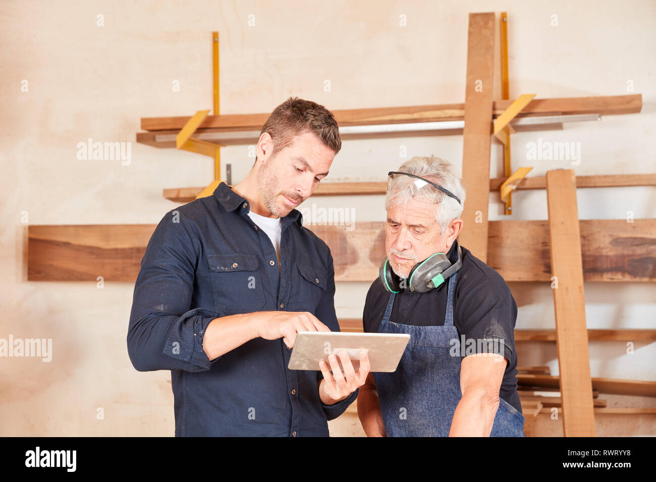 Carpenter using tablet computer shows the master online ordering from ...