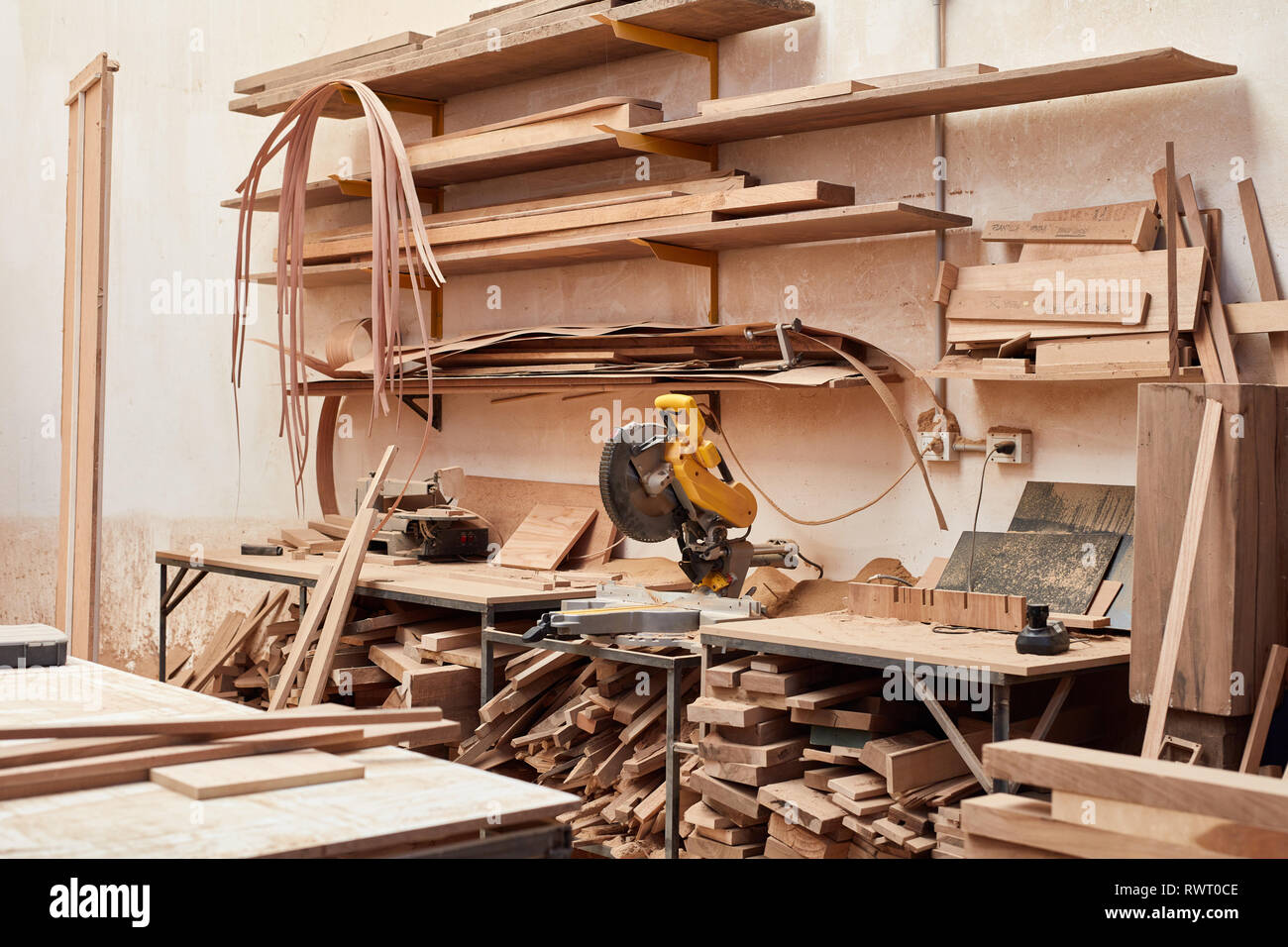 Empty workshop with stock of wood and a chop saw in a carpentry ...