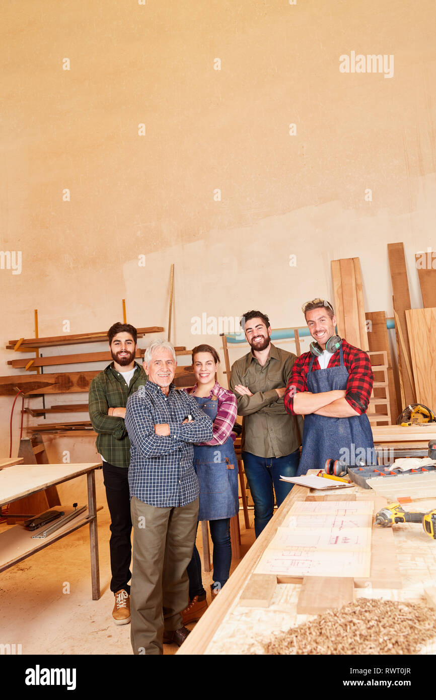 Proud group of craftsmen with senior boss and apprentices in craft ...