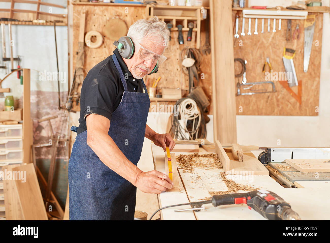 Carpenter master while measuring with the folding rule at the workbench ...