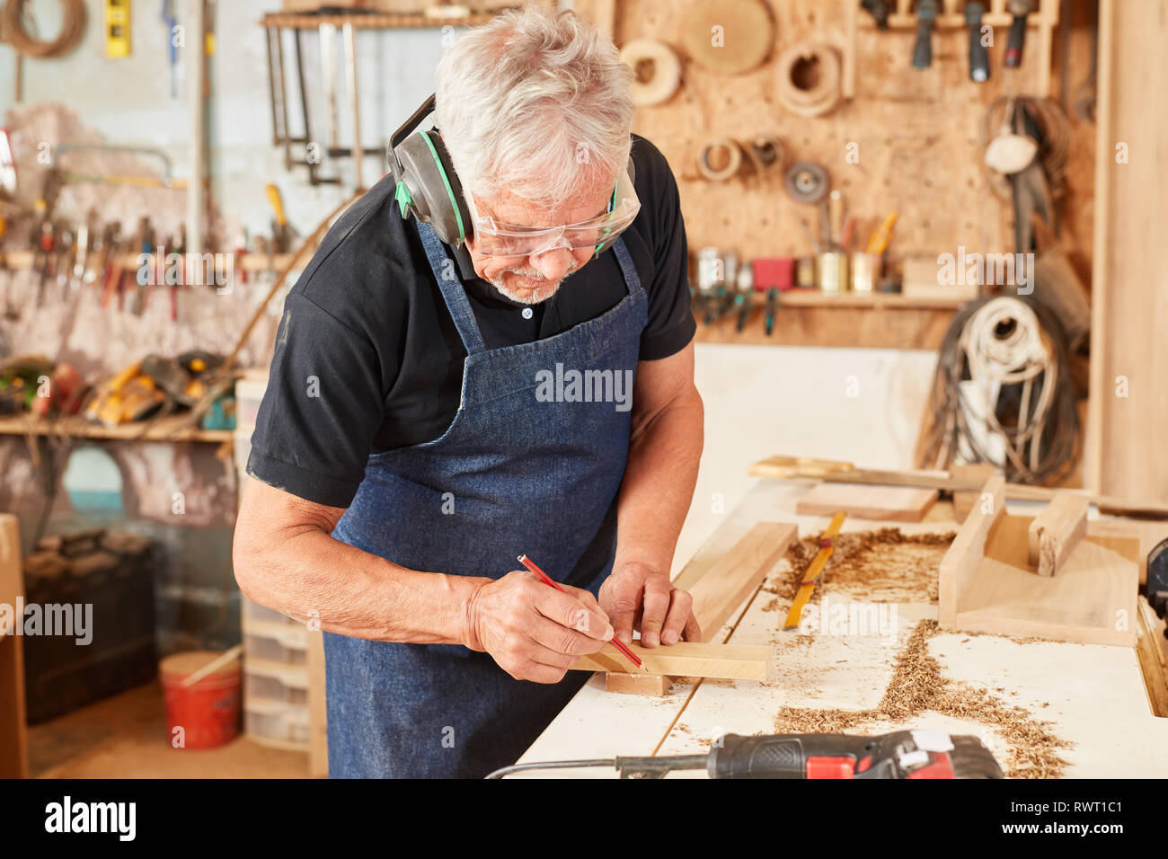 Carpenter master at the workbench when measuring wood with a pencil ...