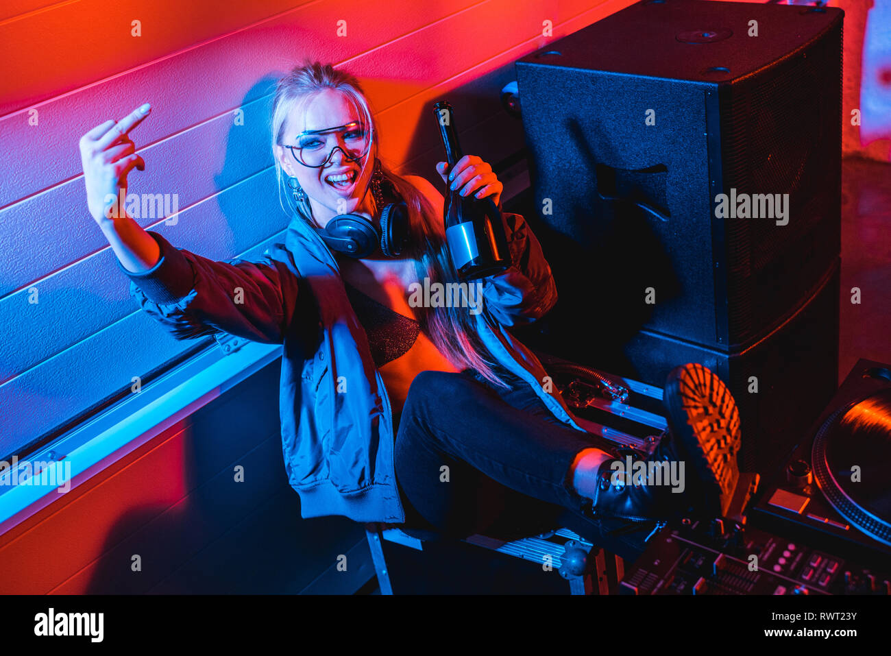 attractive dj woman showing middle finger while holding bottle Stock ...