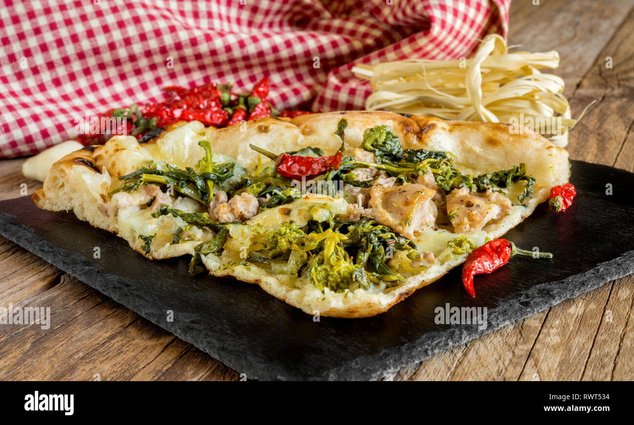 slice of Neapolitan pizza with pork sausages and friarielli broccoli ...