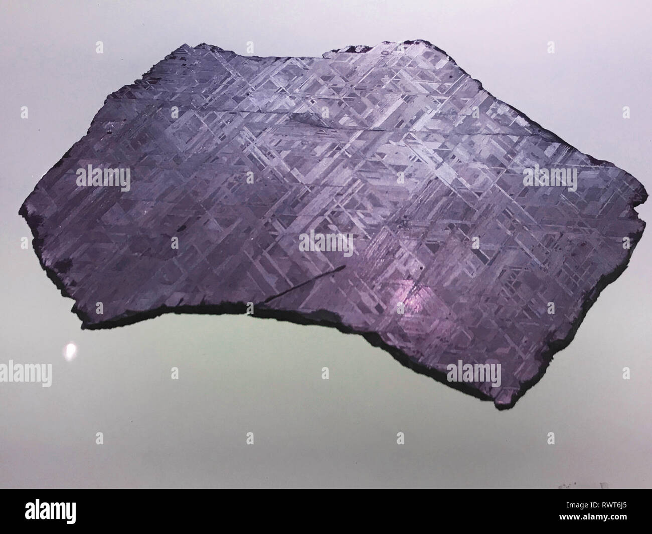 Iron alien meteorite with Widmanstatten pattern on light Stock Photo ...