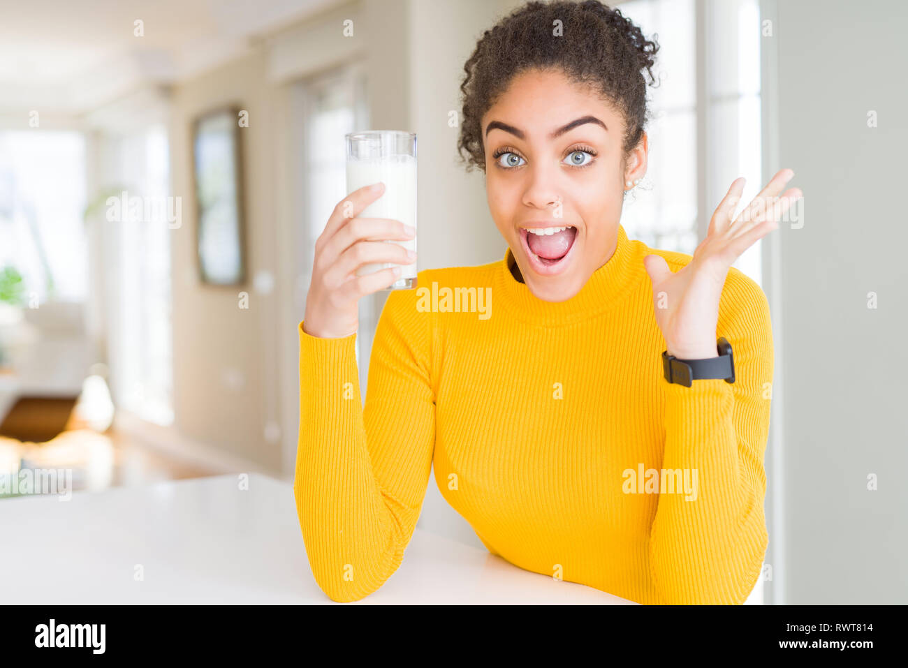 Young african american woman drinking a glass of fresh milk very happy ...
