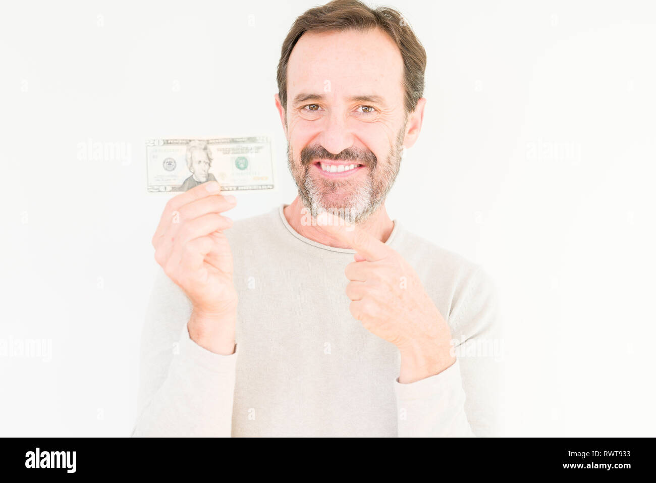 Senior man holding twenty dollars bank note over isolated background ...