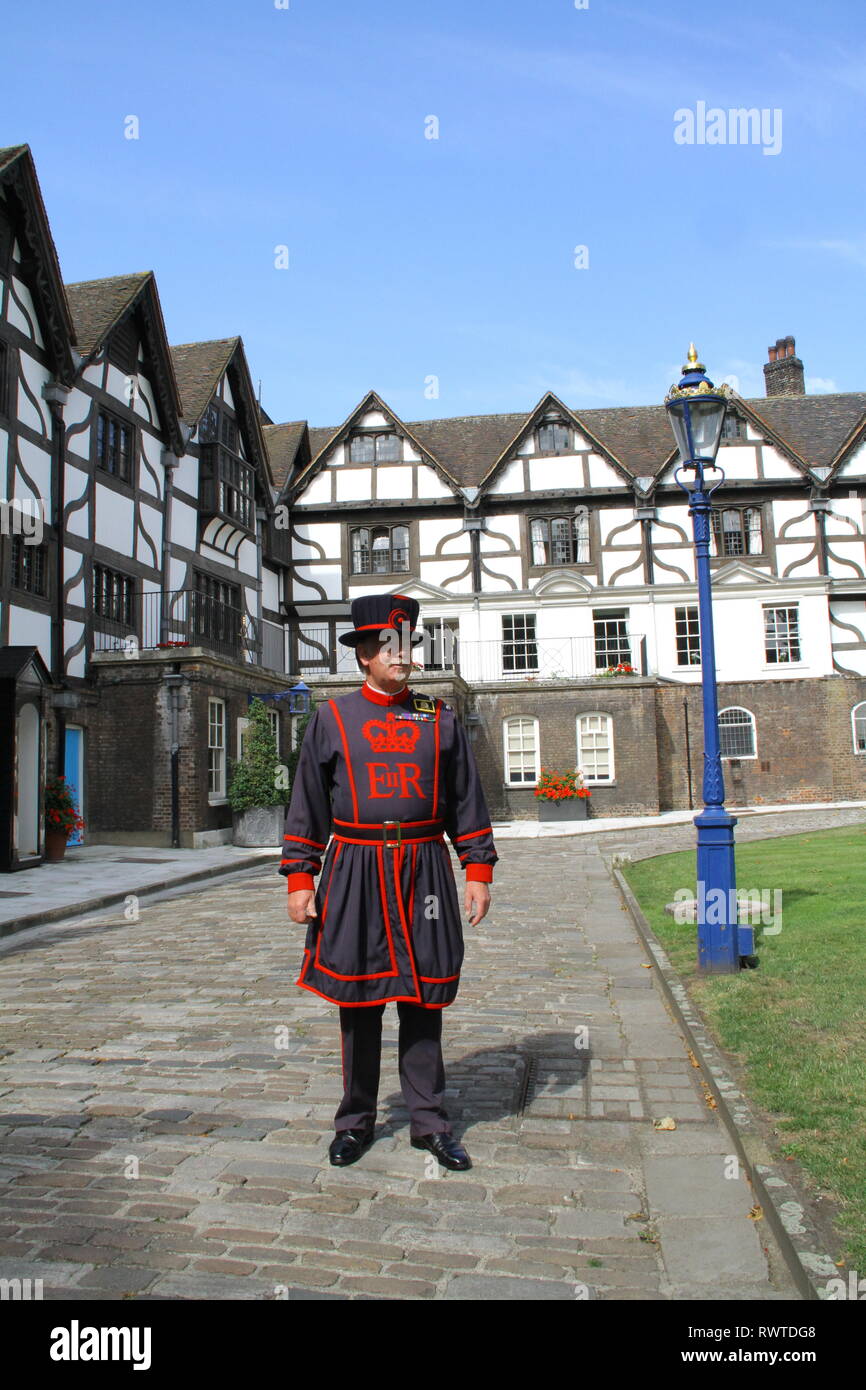 A Beefeater stands in front of the Queens House at The Tower of London ...