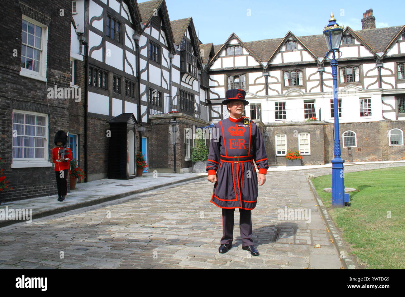 A Beefeater stands in front of the Queens House at The Tower of London ...