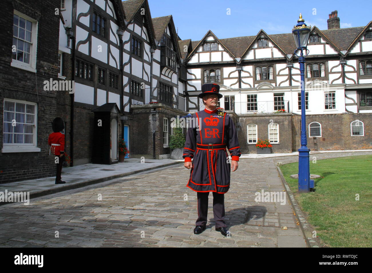 A Beefeater stands in front of the Queens House at The Tower of London ...