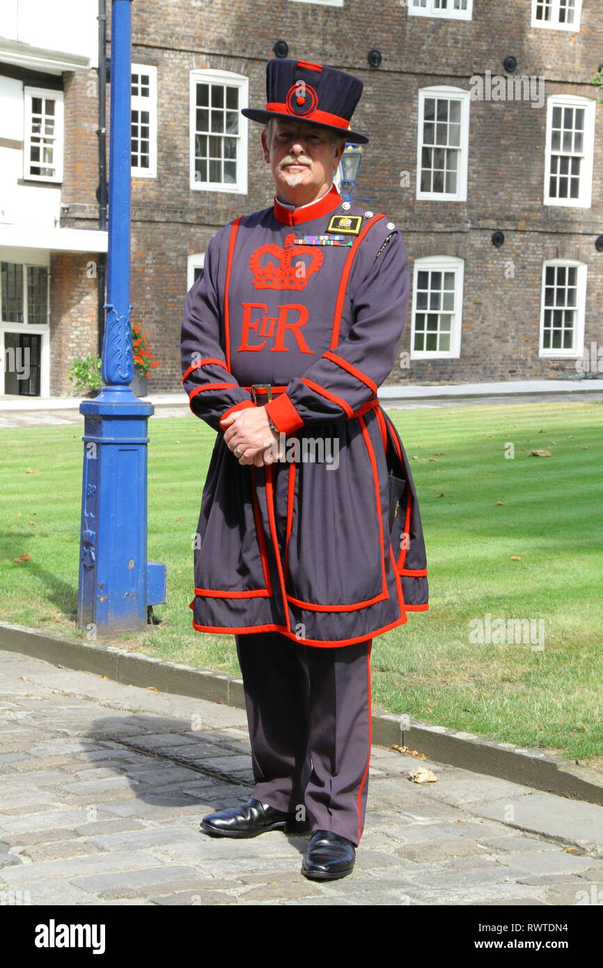 A Beefeater stands in front of the Queens House at The Tower of London ...