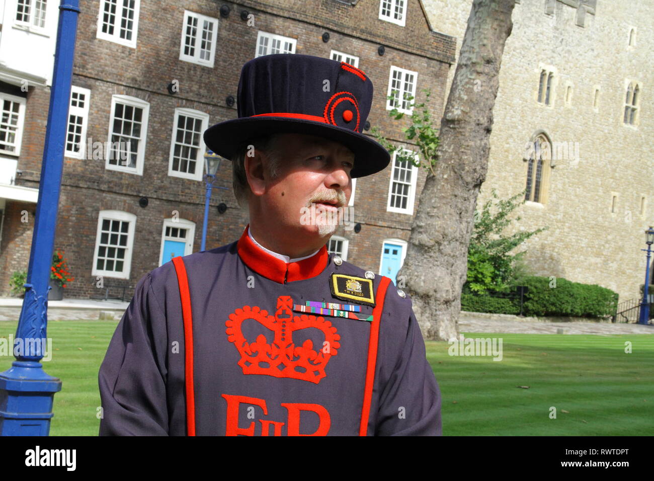 A Beefeater stands in front of the Queens House at The Tower of London ...