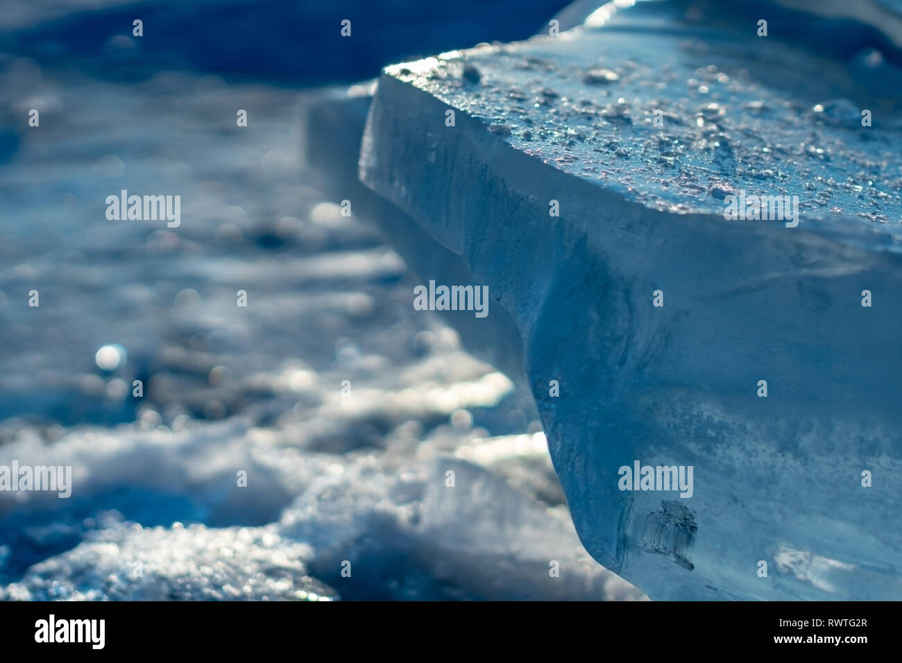 Pieces of clear blue ice of lake Baikal in the winter sunlight. Beauty ...