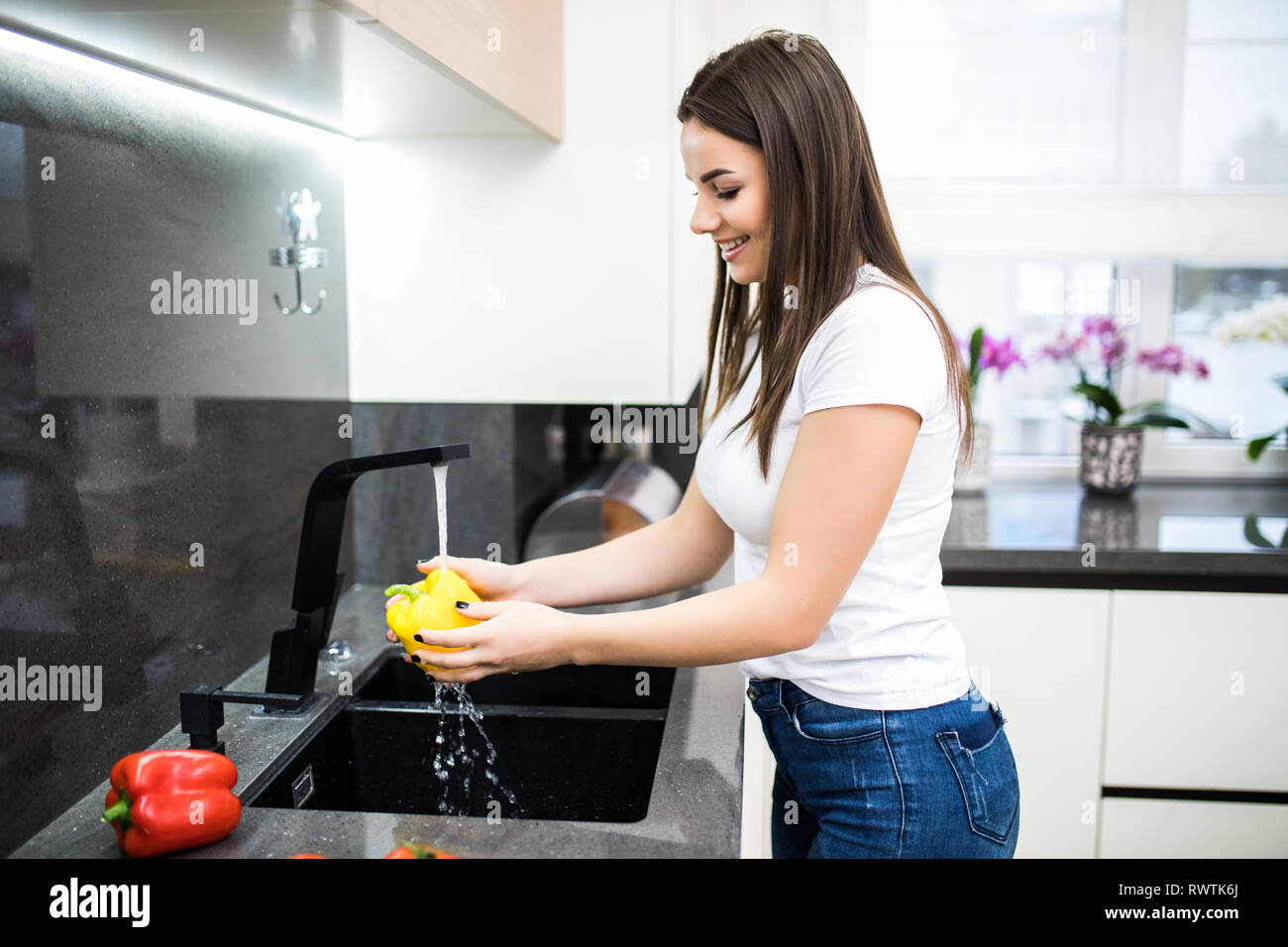 Woman washes vegetables in kitchen hi-res stock photography and images ...