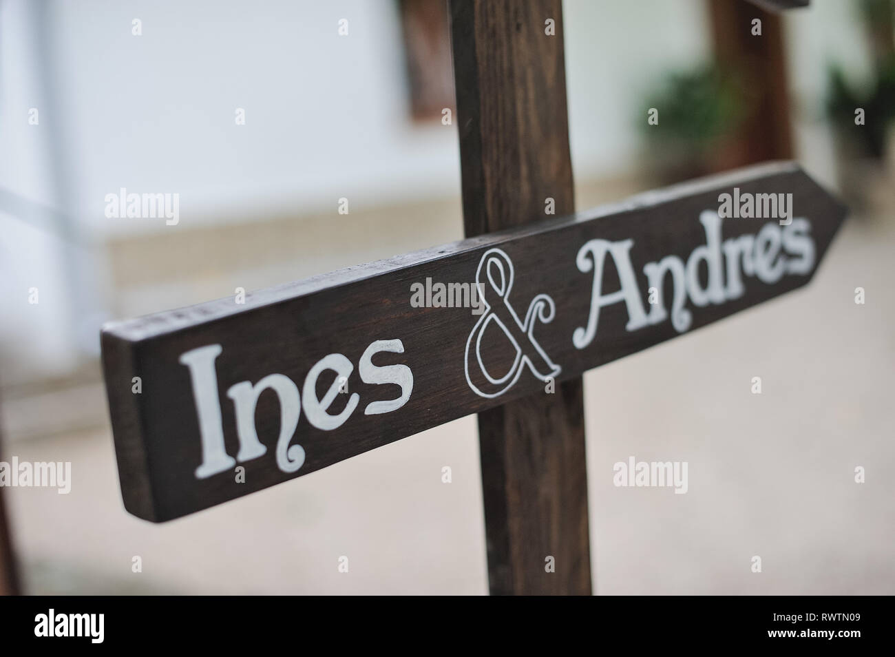 wooden sign in the shape of an arrow with the words Ines and Andres ...