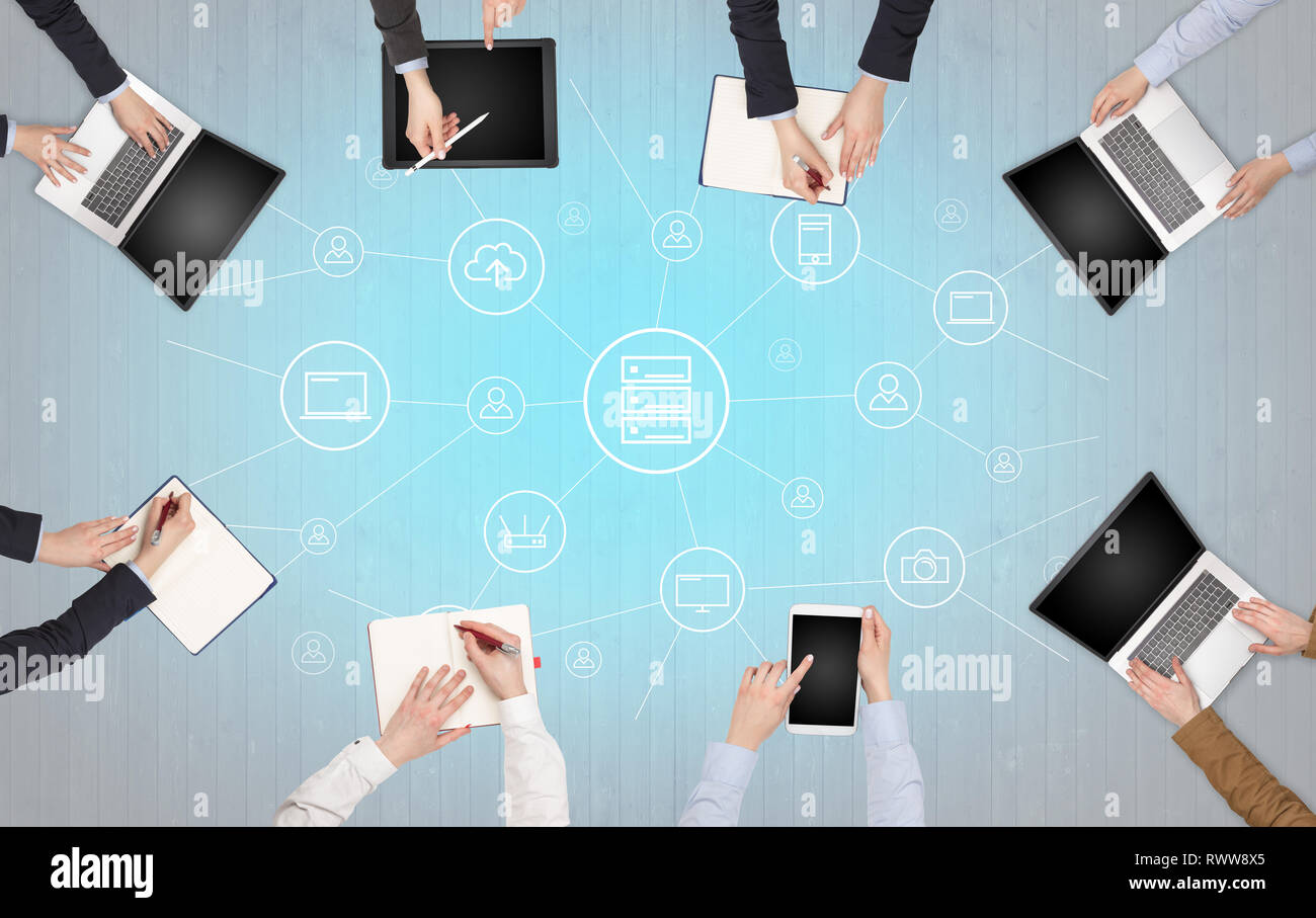 Group of people with devices in hands working in team on tablets ...