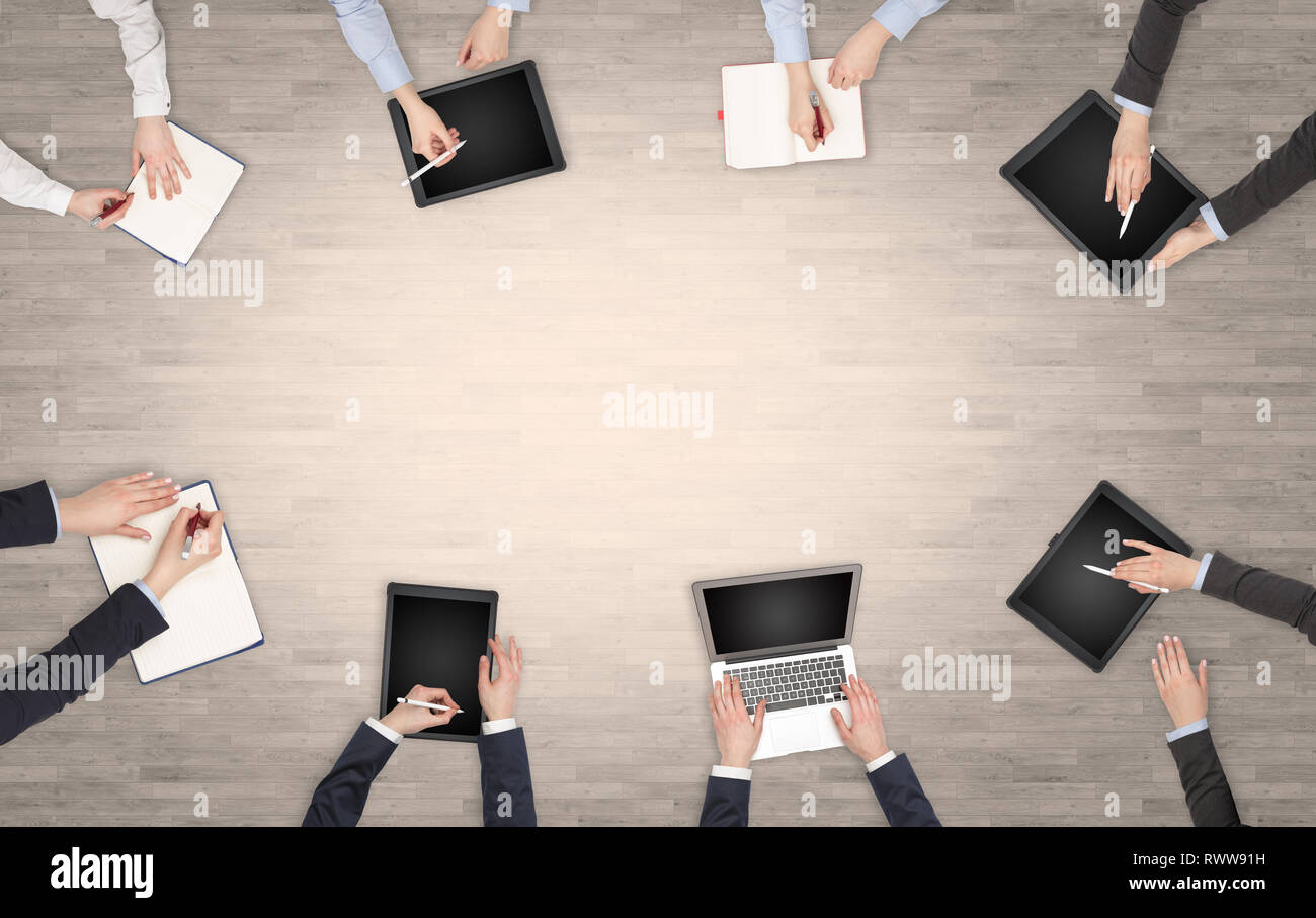 Group of people with devices in hands having desk discussion and making ...