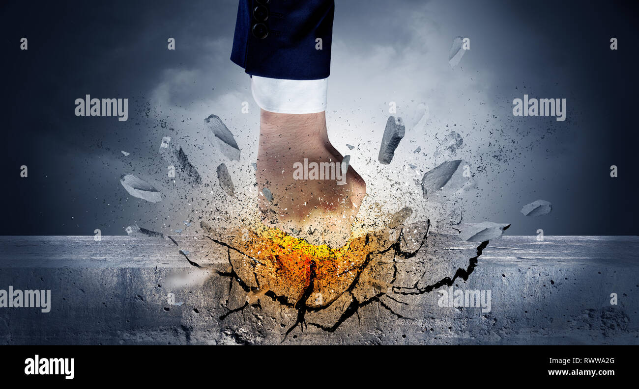 Big hand hits intense and breaks a crass stonewall Stock Photo - Alamy
