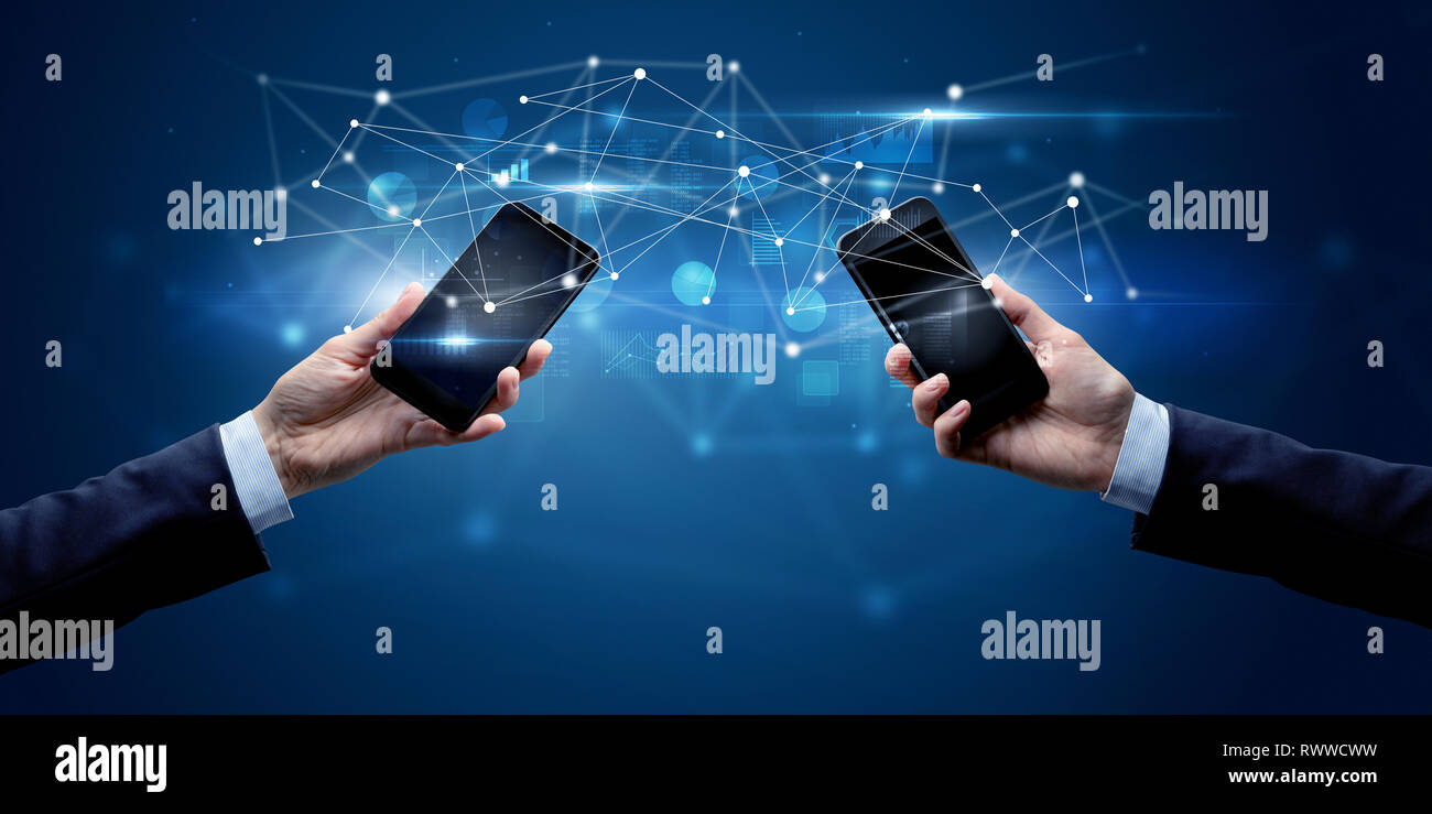 Close up of two hands holding smartphones and sharing business data ...