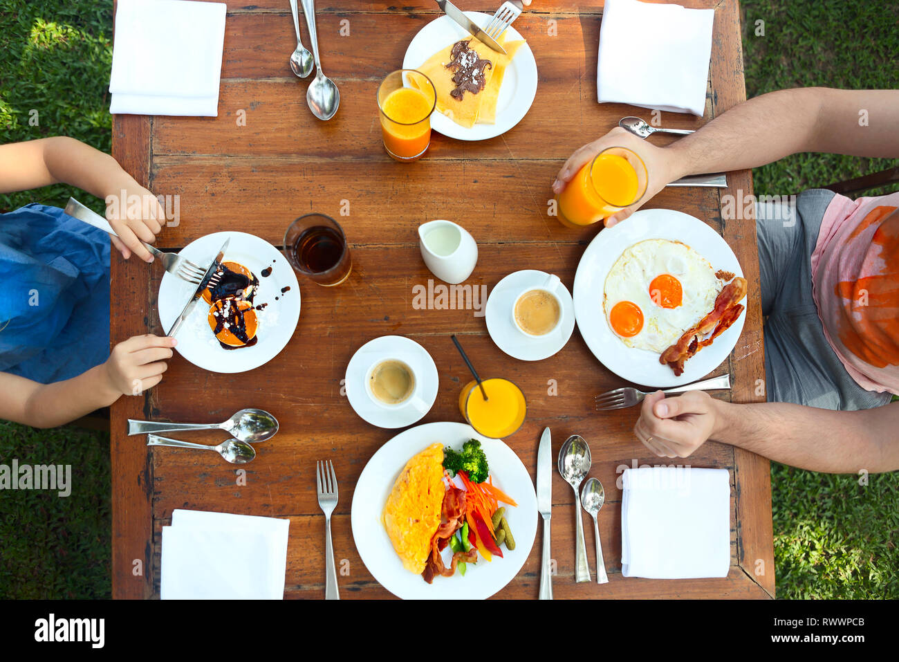 Continental breakfast of the family with pancakes, eggs, bacon, orange ...