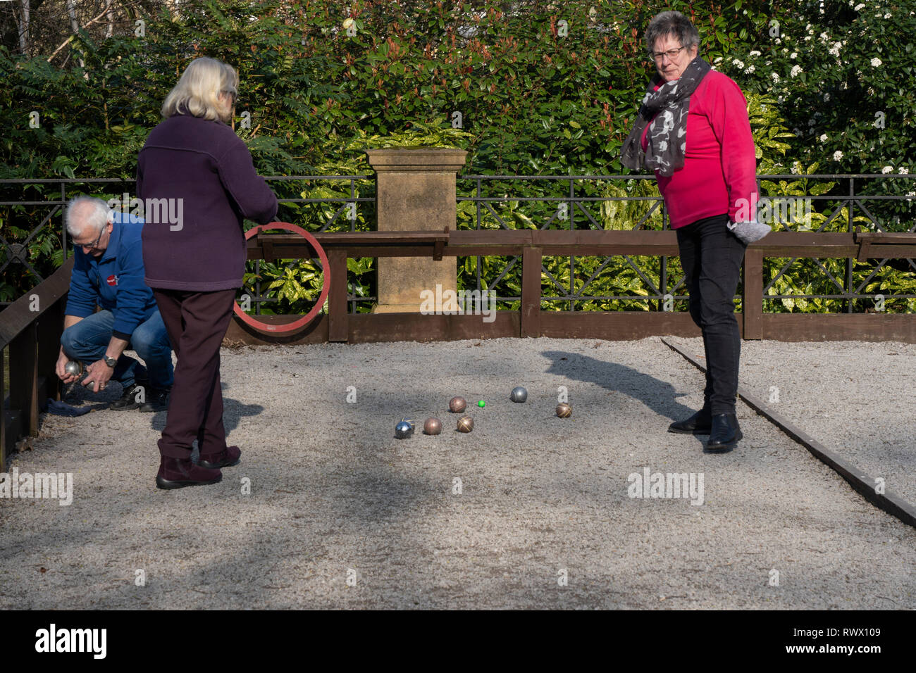 Three people playing a game of Petanque outdoors in Harrogate, North ...