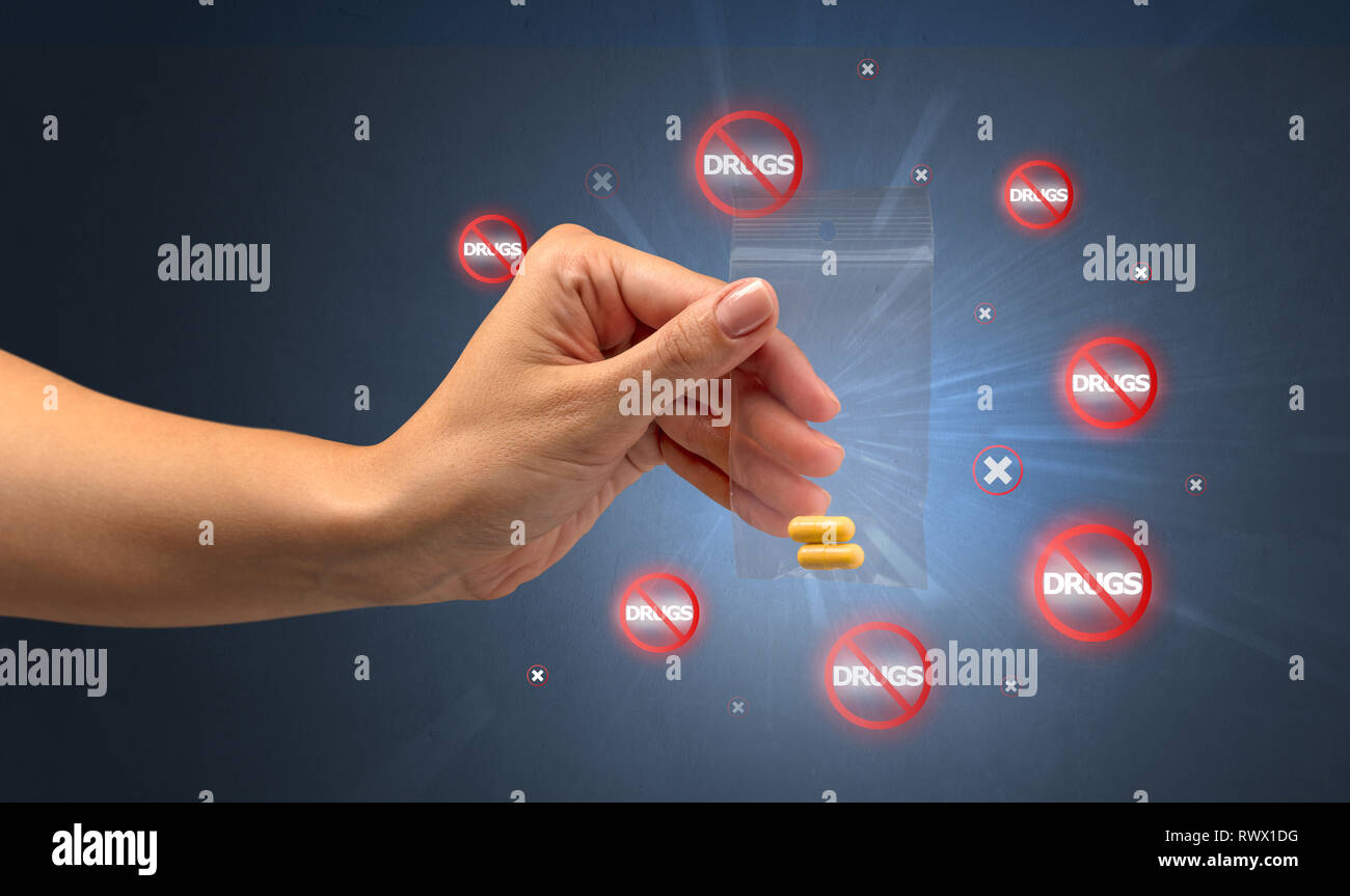 Hand giving pills with anti-drug concept and not allowed signs around ...