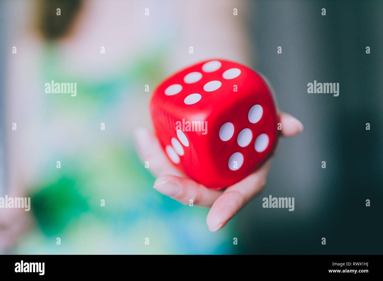 girl handing big red dice shot at shallow depth of field, concept of ...