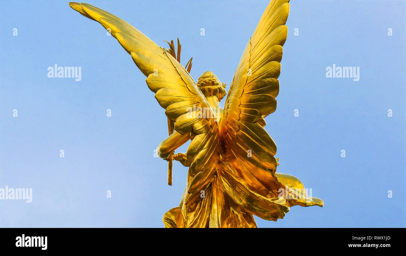 The golden angel statue infront of the palace. Seen are the statue of ...