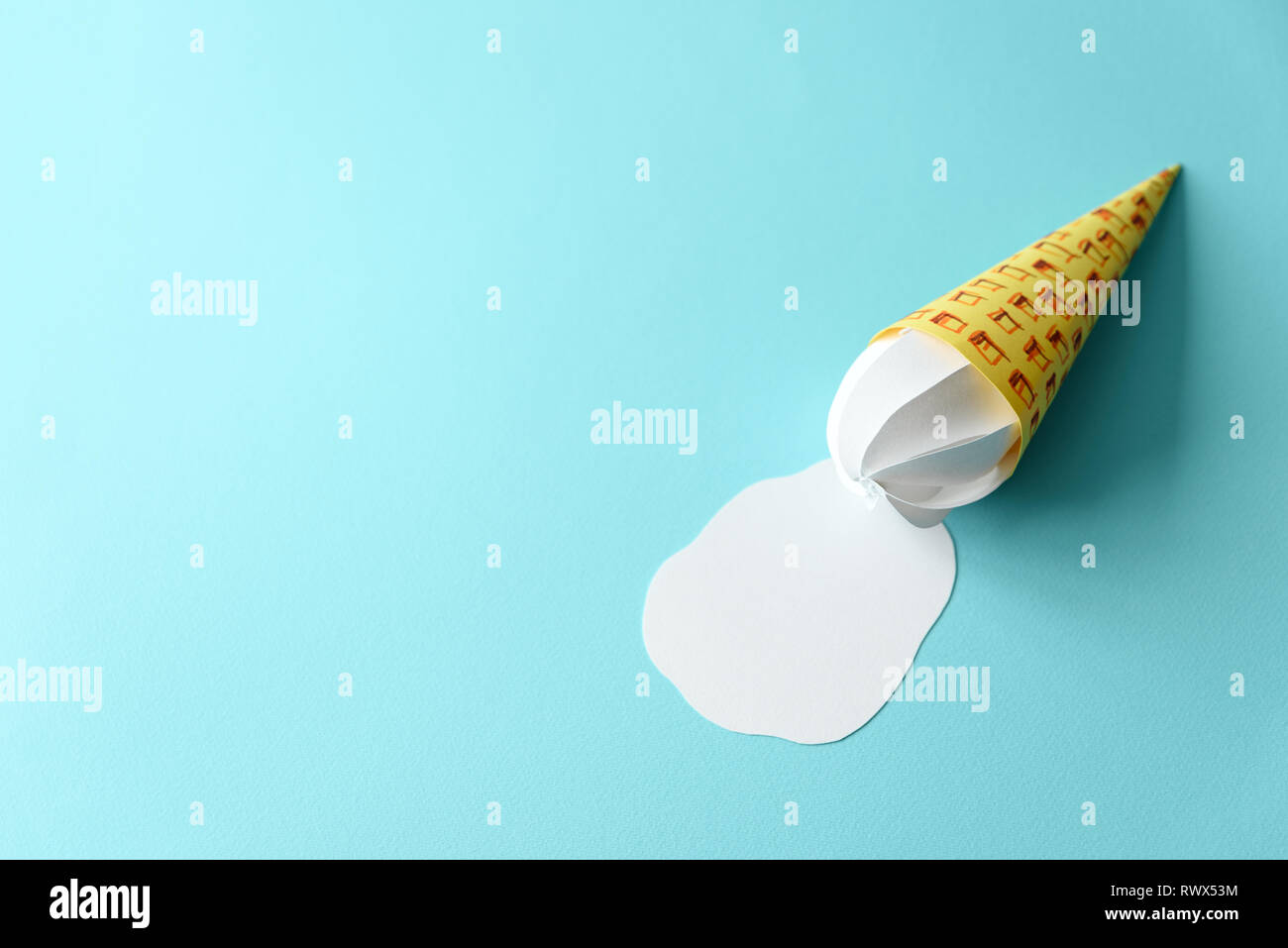 Melted paper vanila ice-cream cone on blue background. Copy space ...