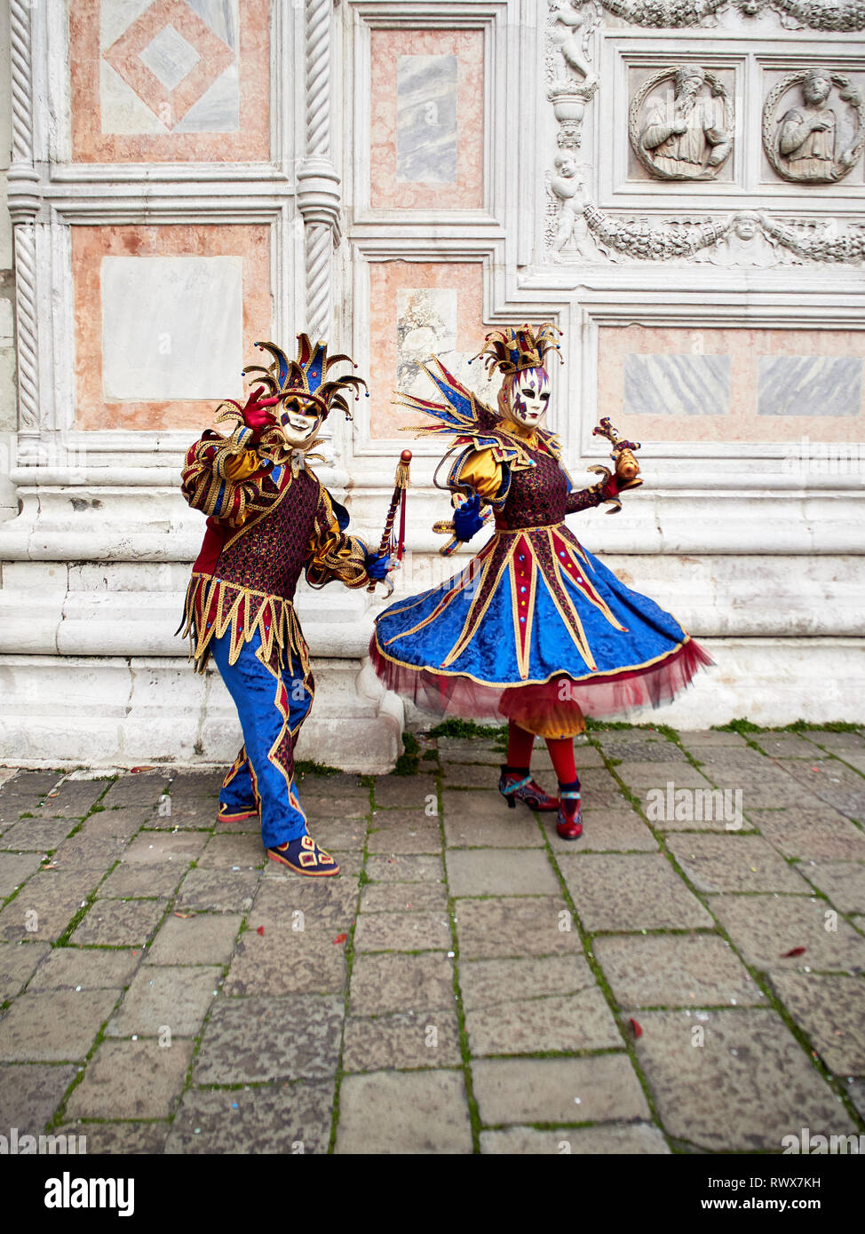 Venice, Italy - March 1, 2019 A couple is dressed with an harlequin ...