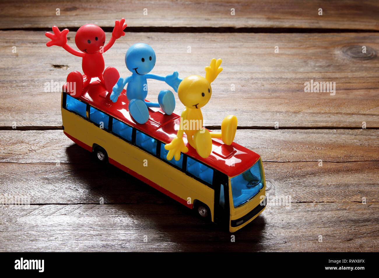 Figures on Toy Bus with Wooden Background Stock Photo - Alamy