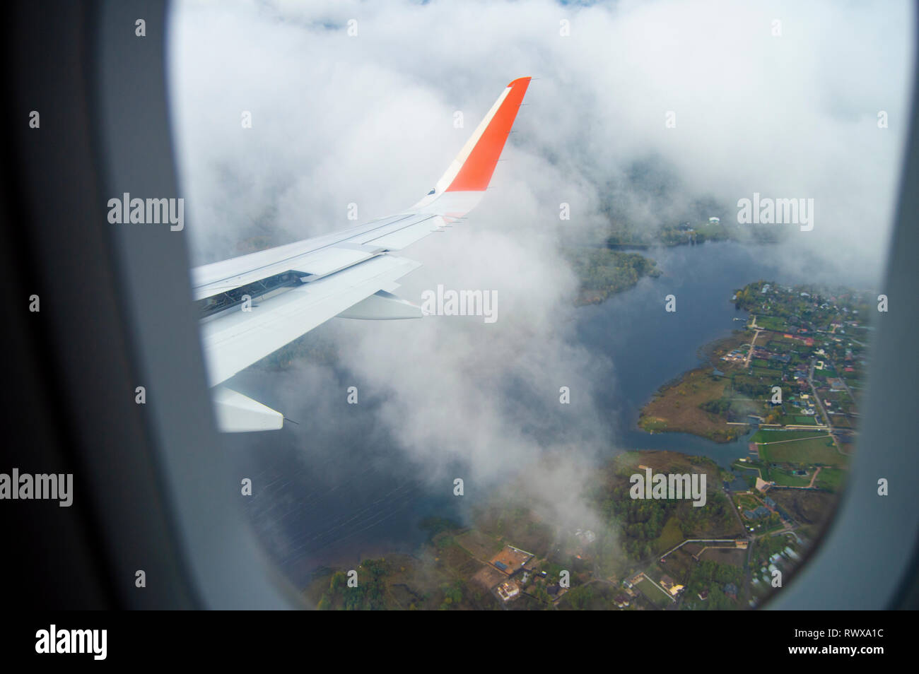 View from the window of the aircraft on the buildings and trees, the ...