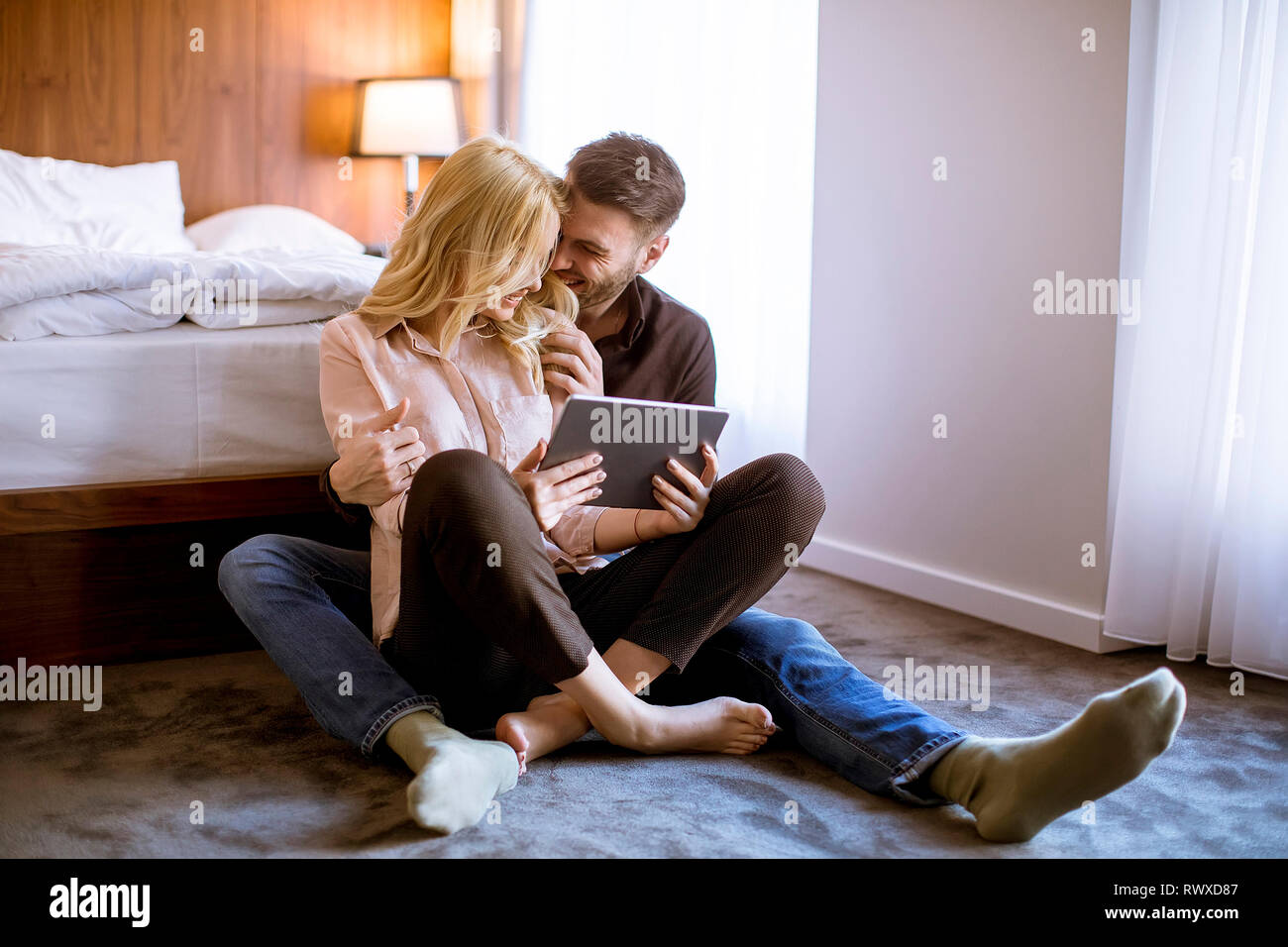 Romantic young happy couple in love sitting on floor resting and having ...