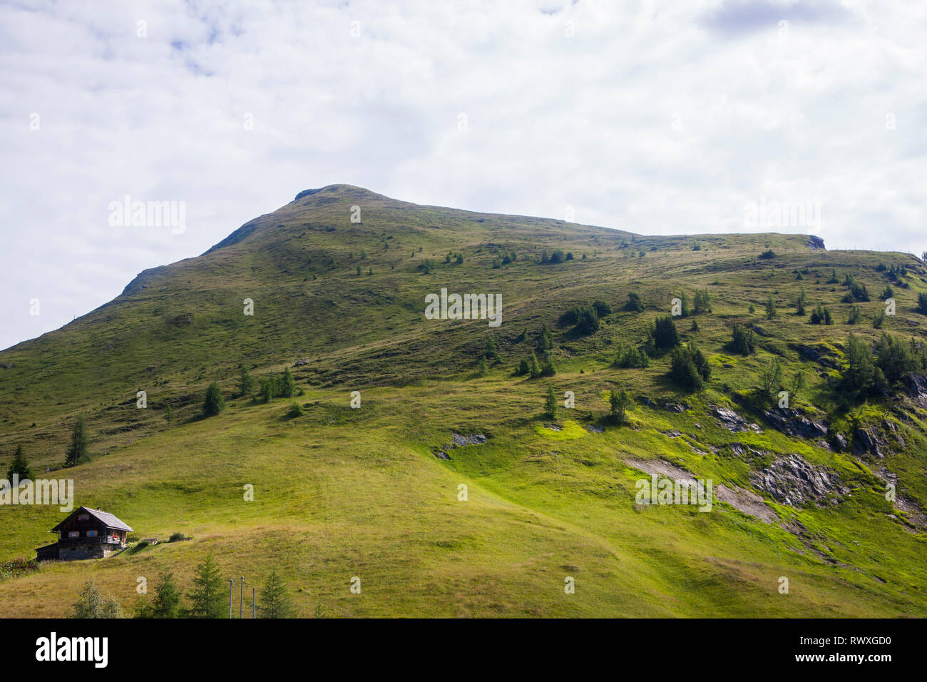Wooden house on a green slope in Austrian Alps Stock Photo - Alamy