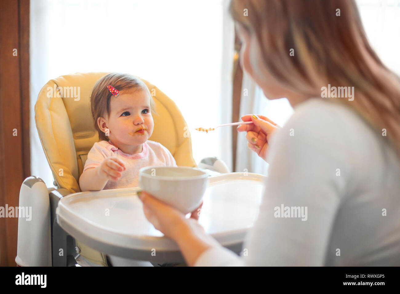 Mother feeding an adorable toddler girl healthy baby food Stock Photo ...