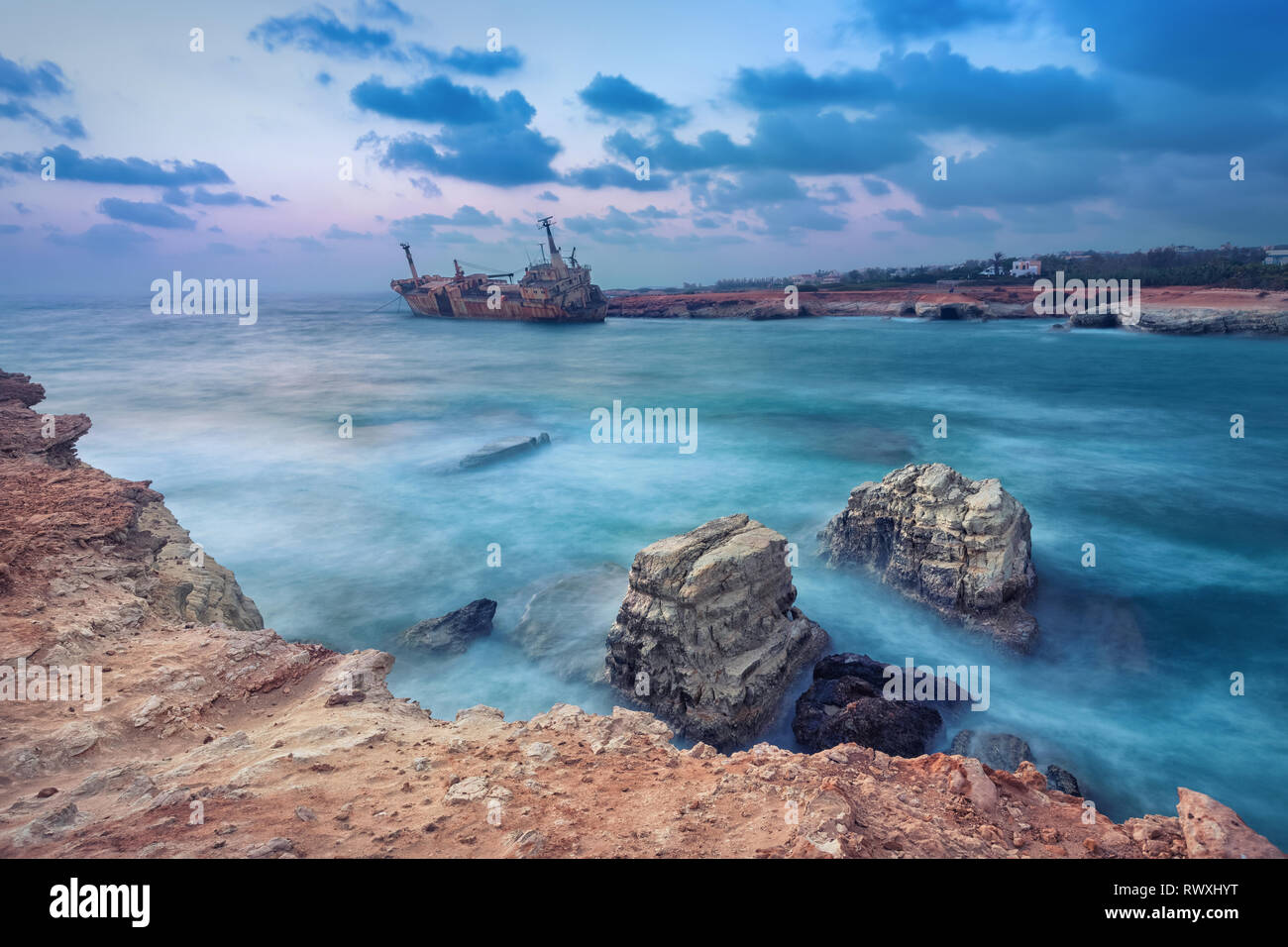 Rocks in sea with abandoned ship on background near Paphos, Cyprus ...