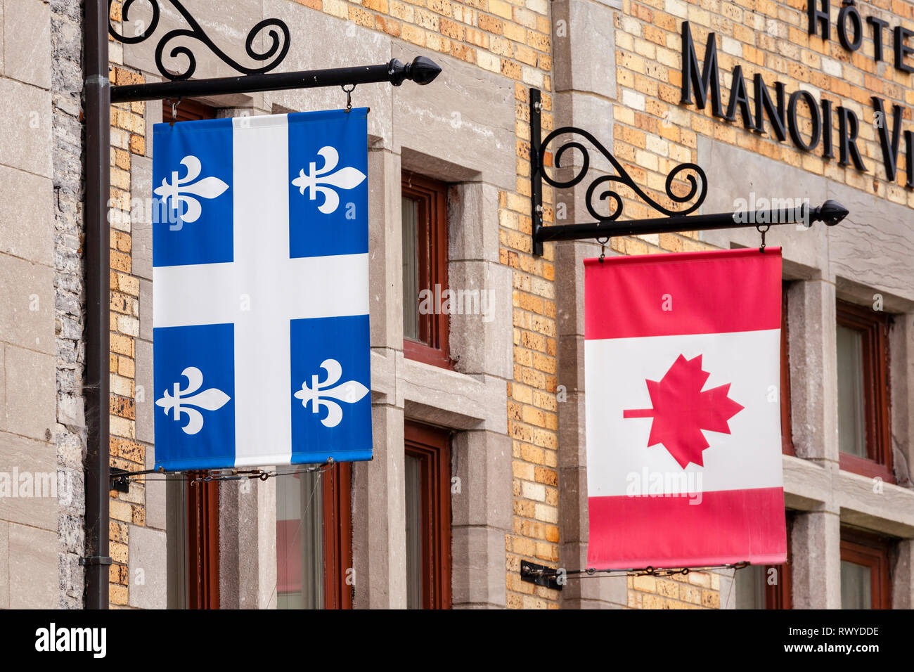 Canadian National Flag and Quebec Provincial flag hanging from vintage ...