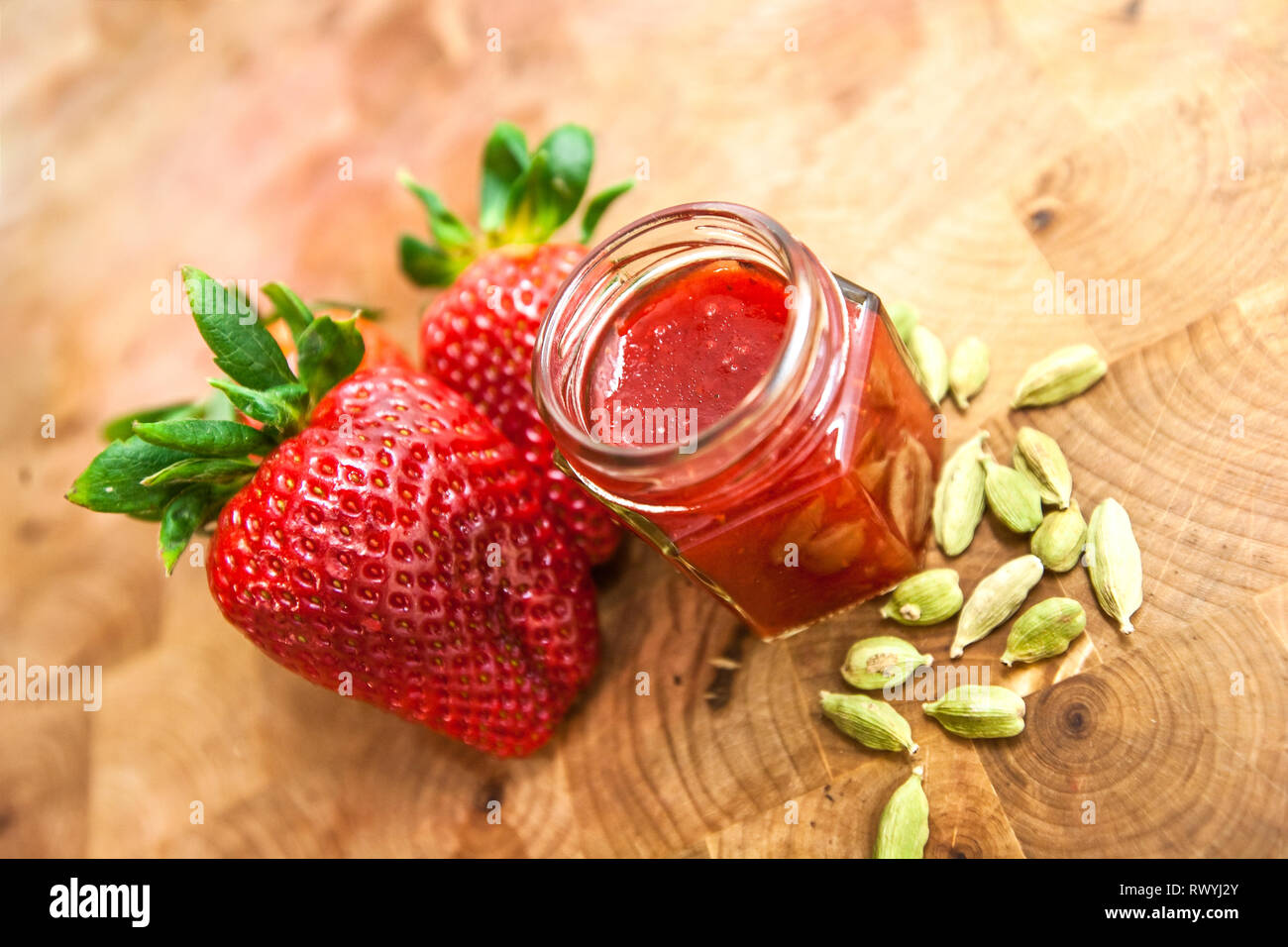 Strawberry jam in a jar on wooden background Stock Photo - Alamy
