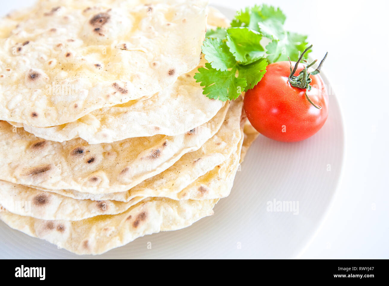 Pita bread on a white background with a tomato Stock Photo - Alamy