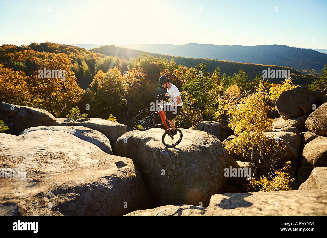 Professional cyclist riding on back wheel on trial bicycle, sportsman ...