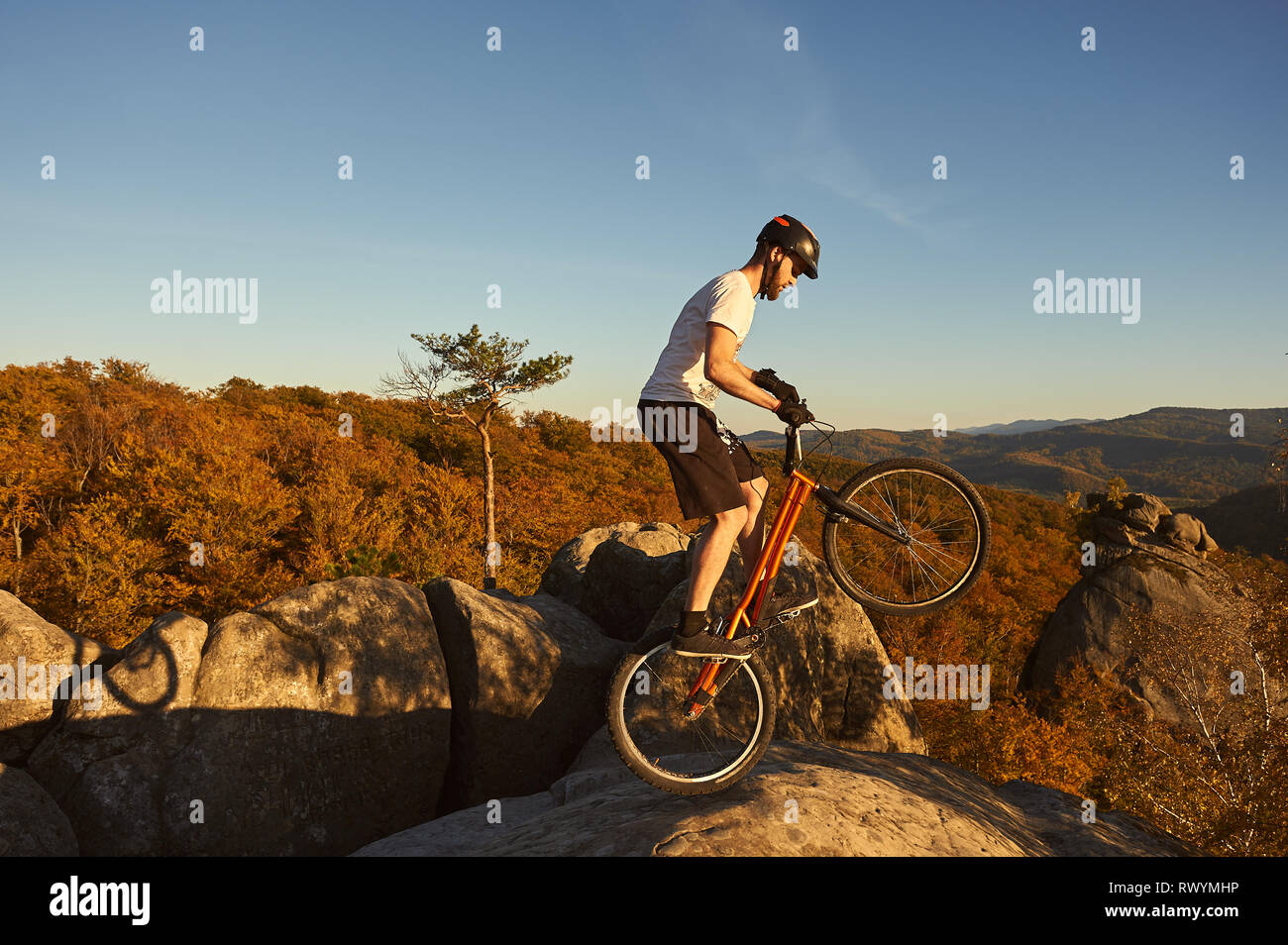 Professional cyclist balancing on back wheel on trial bicycle. Young ...