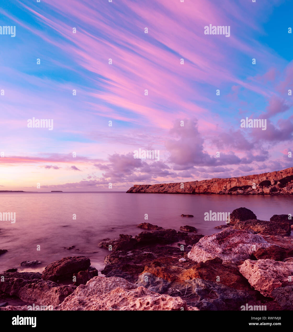Beautiful colorful sunrise at the sea with dramatic clouds and boulders ...